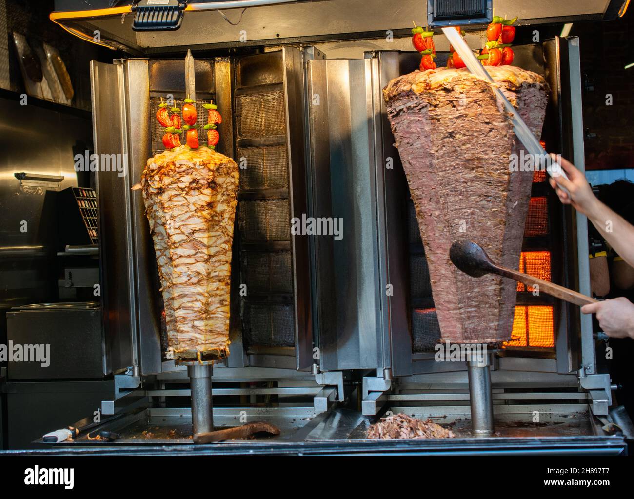 A fresh meat cooking on a rotating vertical spit, street food cooking ...