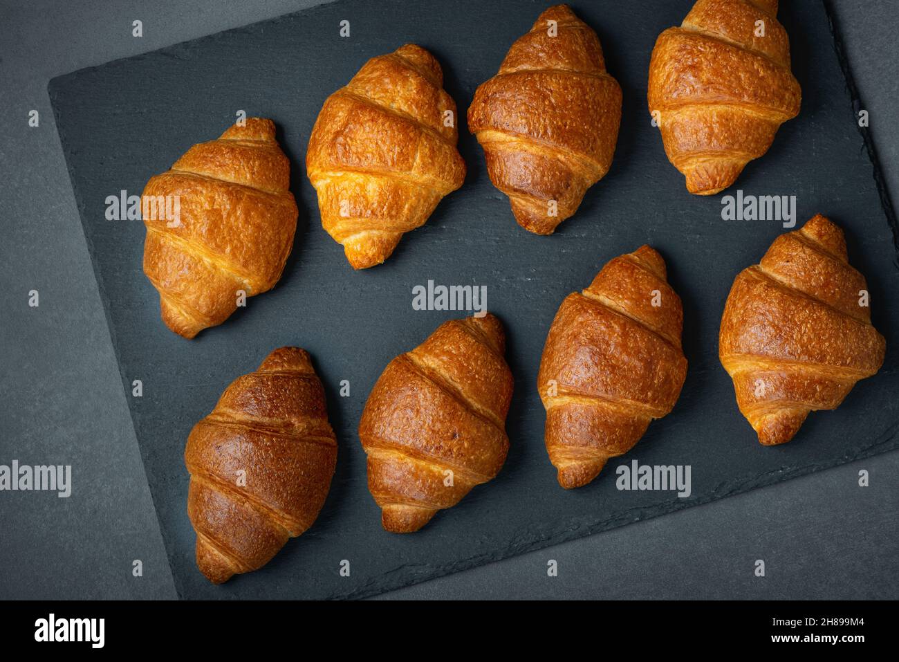 Group of croissant arranged in two rows and ready at the table for ...