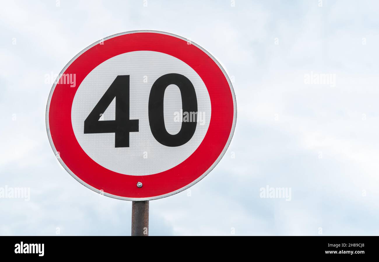 Close-up of a 40 speed limit road sign on a sky background with clouds ...