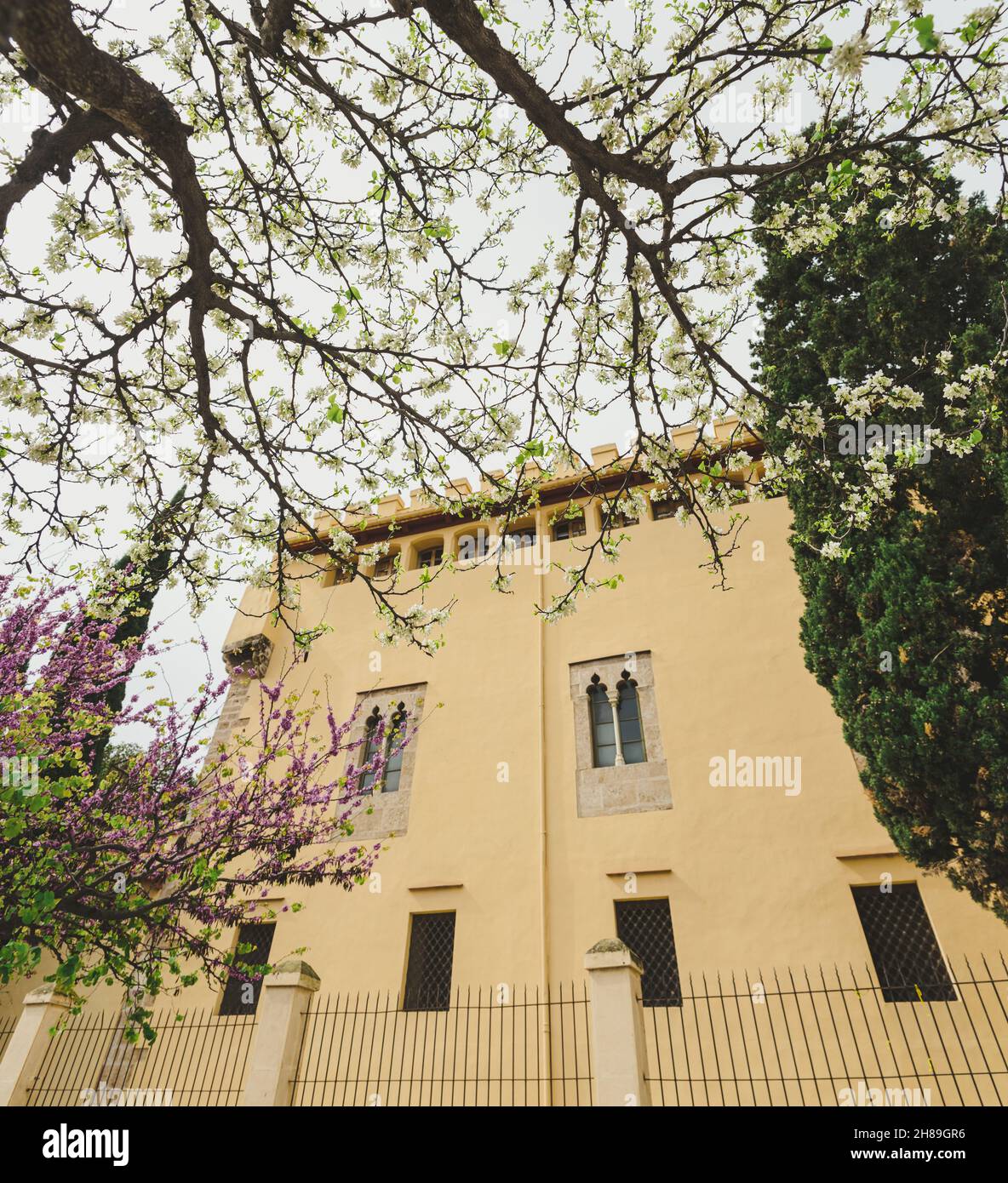 Facade of a secluded modern monastery with fences seen among the pretty ...