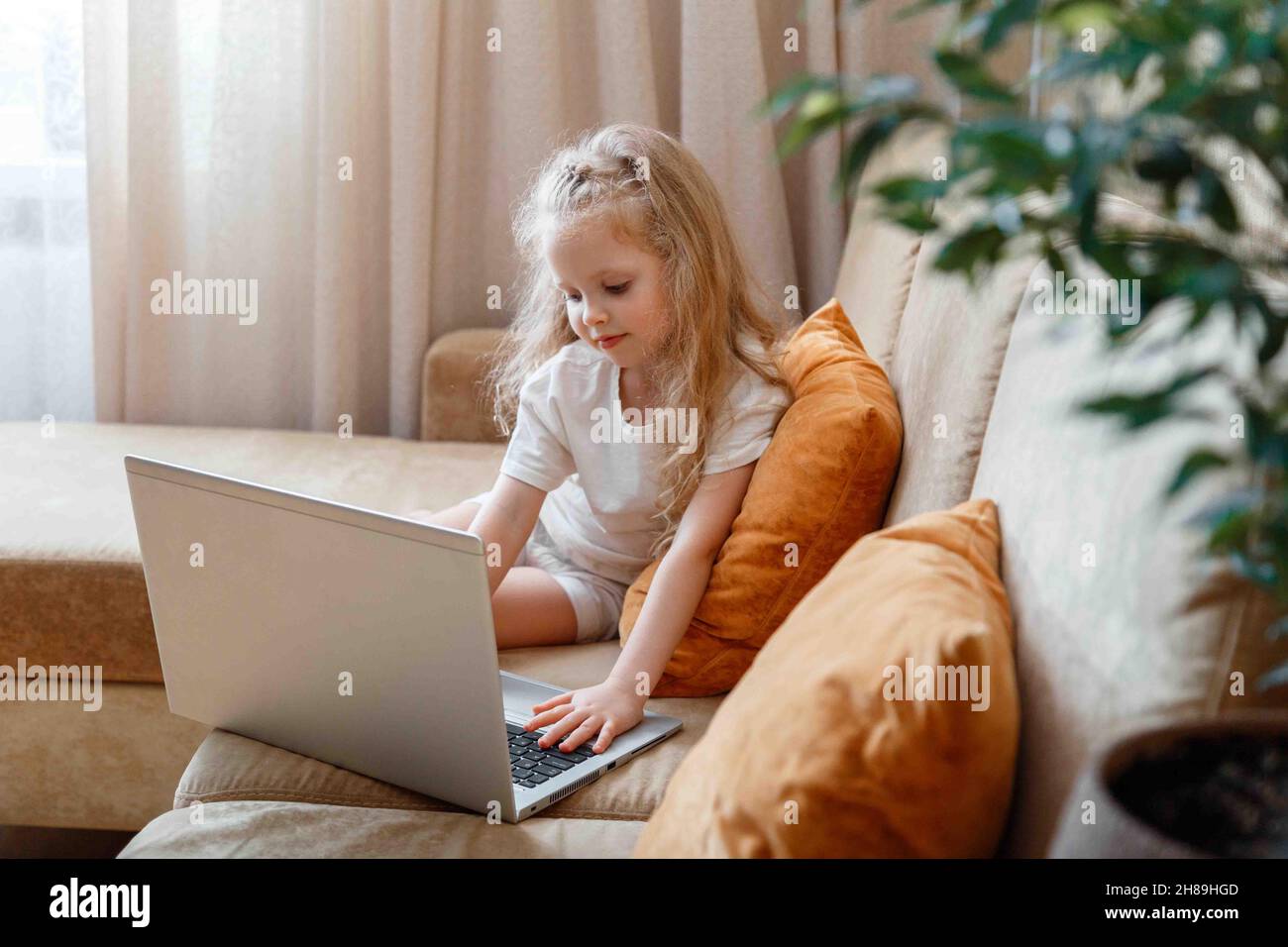 Preschooler girl kid use laptop for remote learning in kindergarten ...