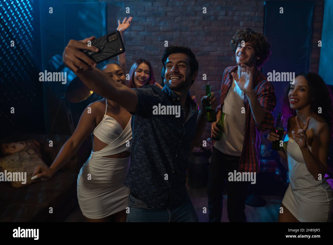 Diverse group of young people dancing at the night club, and taking a ...