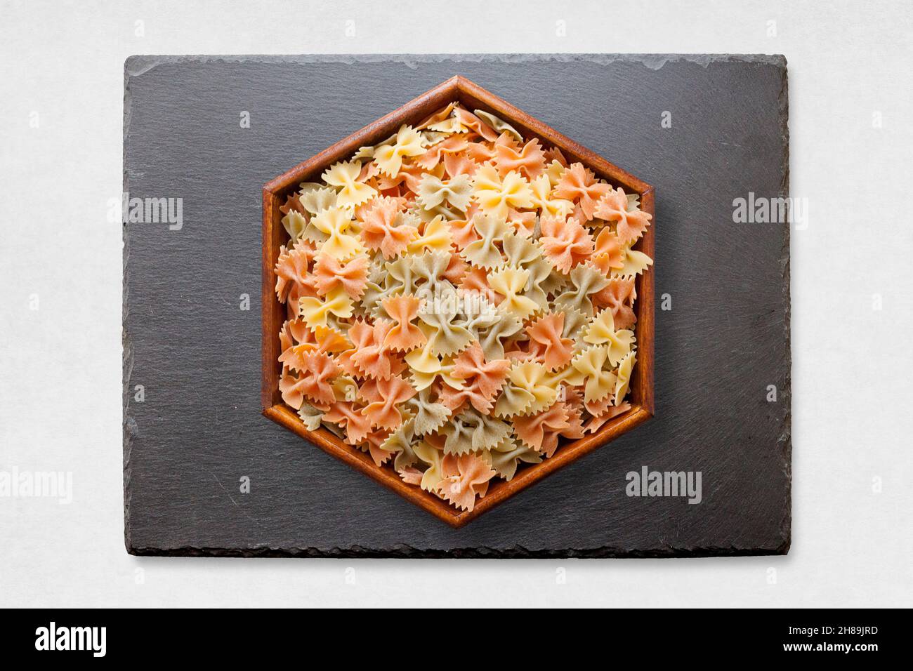 Slate tray on a white surface with on its middle, an hexagonal wooden ...