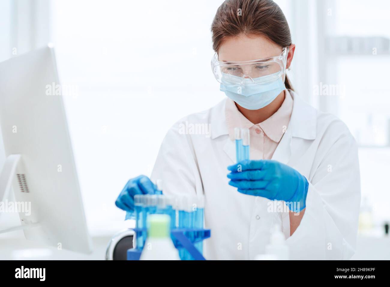close up .female scientist looking at test tube Stock Photo - Alamy