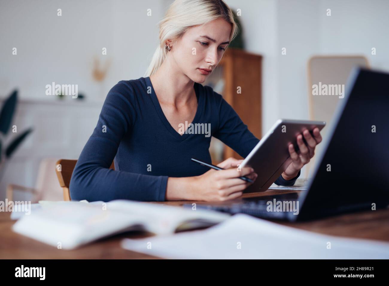 Female student at home studying at table with tablet Stock Photo - Alamy