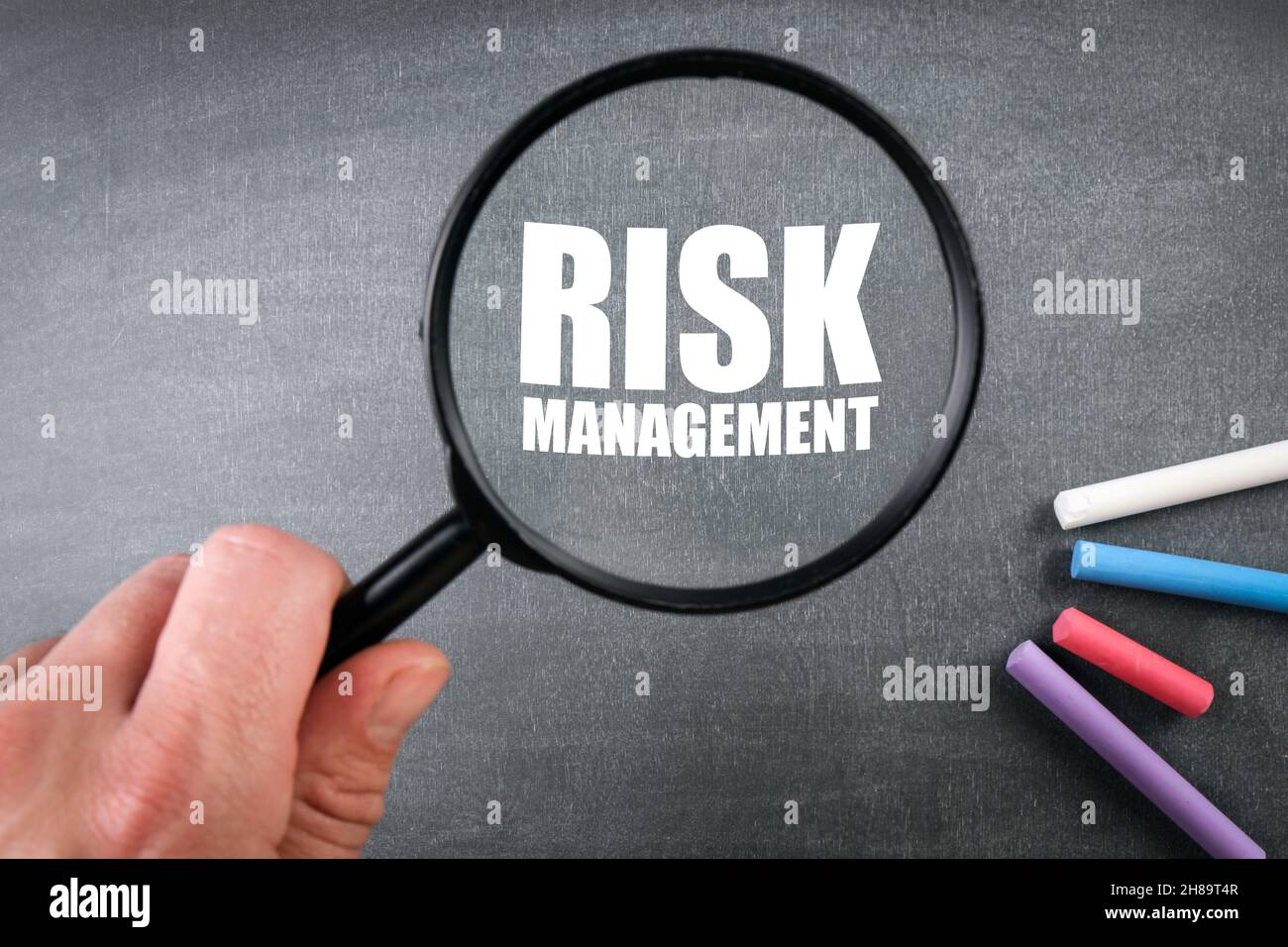 Risk Management concept. Magnifying glass in a man's hand on a ...