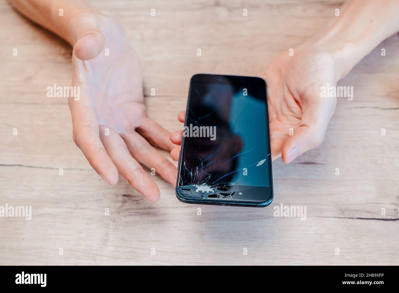 smartphone with a cracked screen in the hands of a young man Stock ...