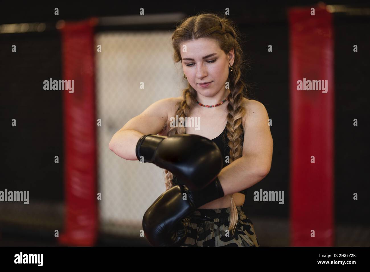 A young woman with braids prepares for a workout, she puts on and ...