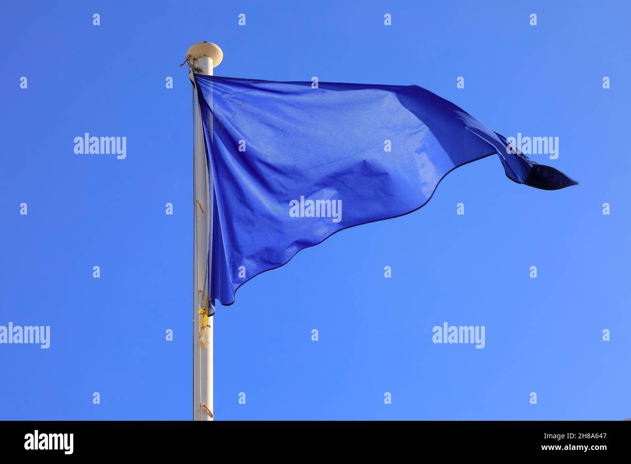 The wind blows with a blue triangular flag, which is placed on the mast ...