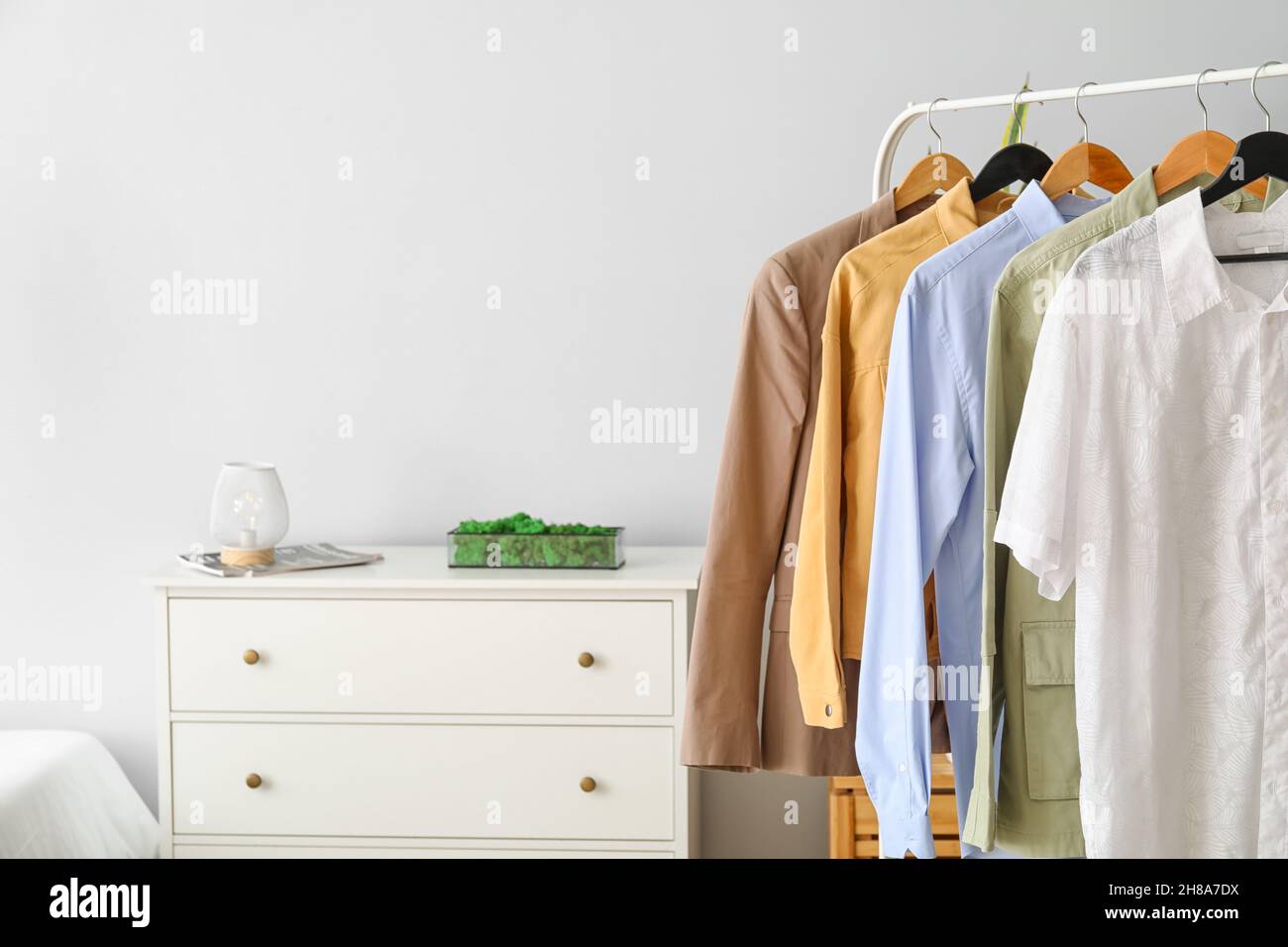 Rack with stylish clothes in light room Stock Photo - Alamy
