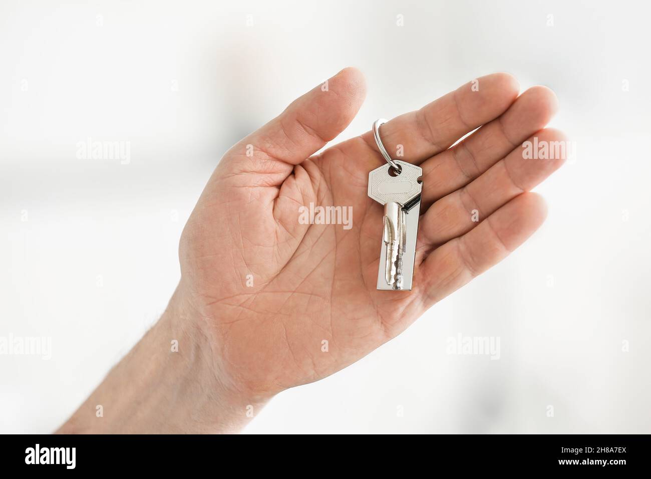 Male hand holding key on chain Stock Photo - Alamy
