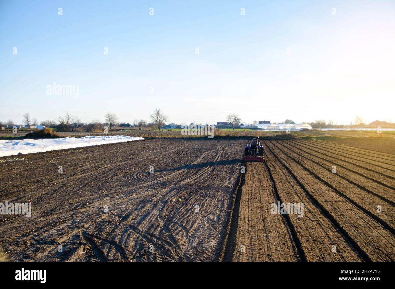 Half of the cultivated field and the farmer on the tractor. Farming ...