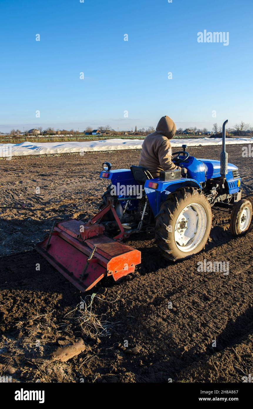A farmer is cultivating the farm field. Seasonal worker. Recruiting ...