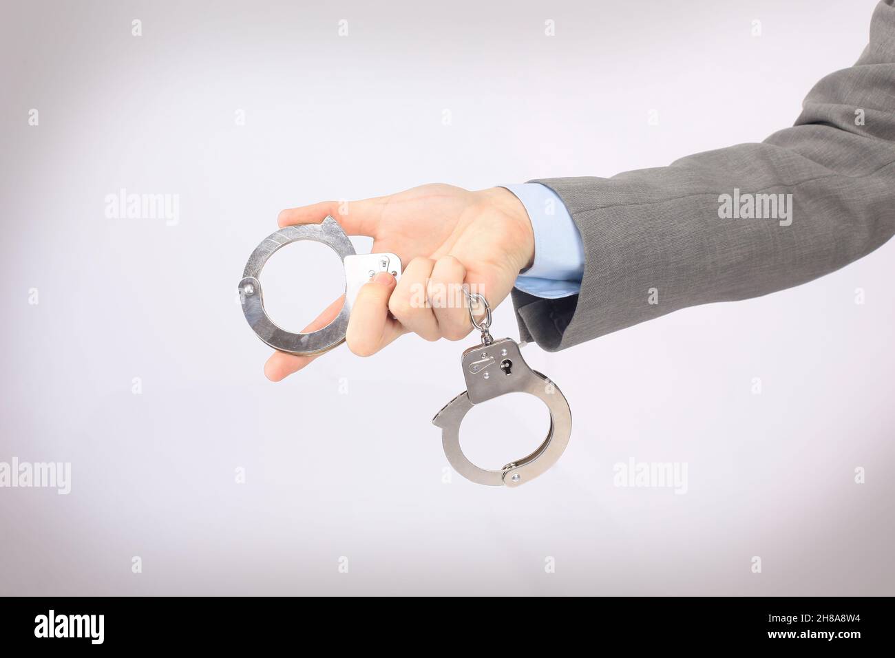 The hand holding the handcuffs. Isolated on a white background Stock ...