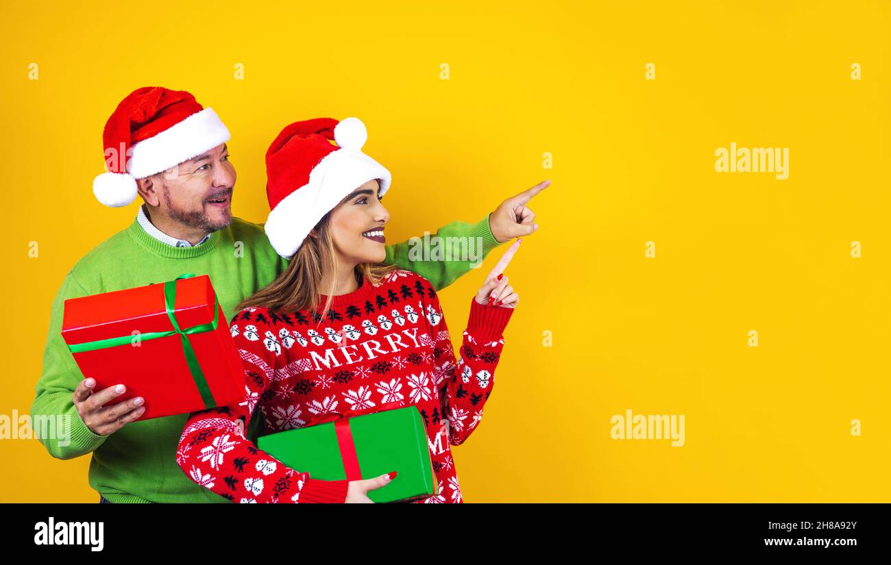 latin father and daughter in red sweater Christmas santa hat holding ...