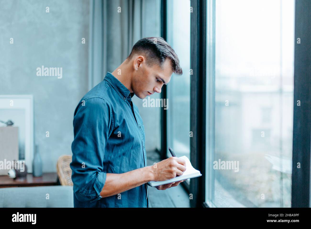 Businessman standing window looking distance hi-res stock photography ...