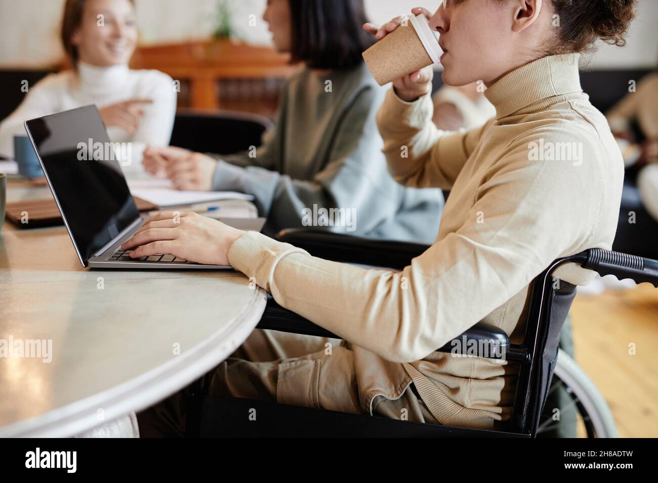Student with disability using wheelchair sitting at the table and ...