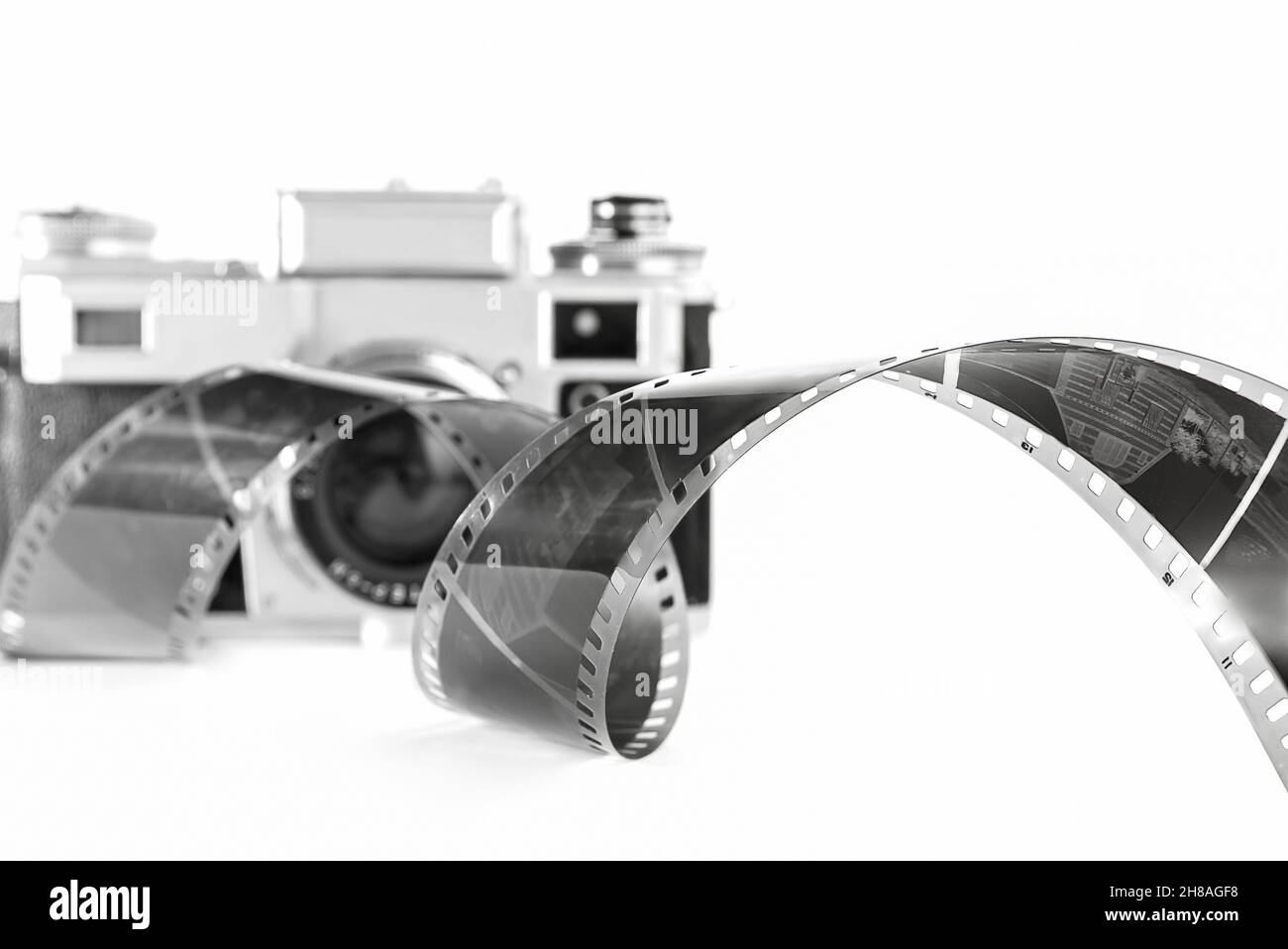 retro camera and camera roll on white background. Black and white photo ...