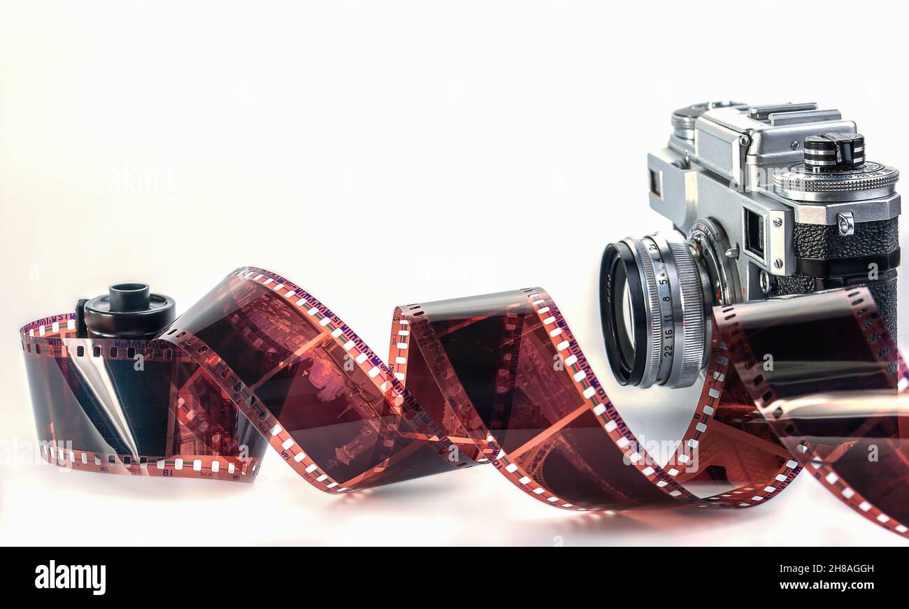 still life with retro analog camera, camera roll and cassettes on white ...