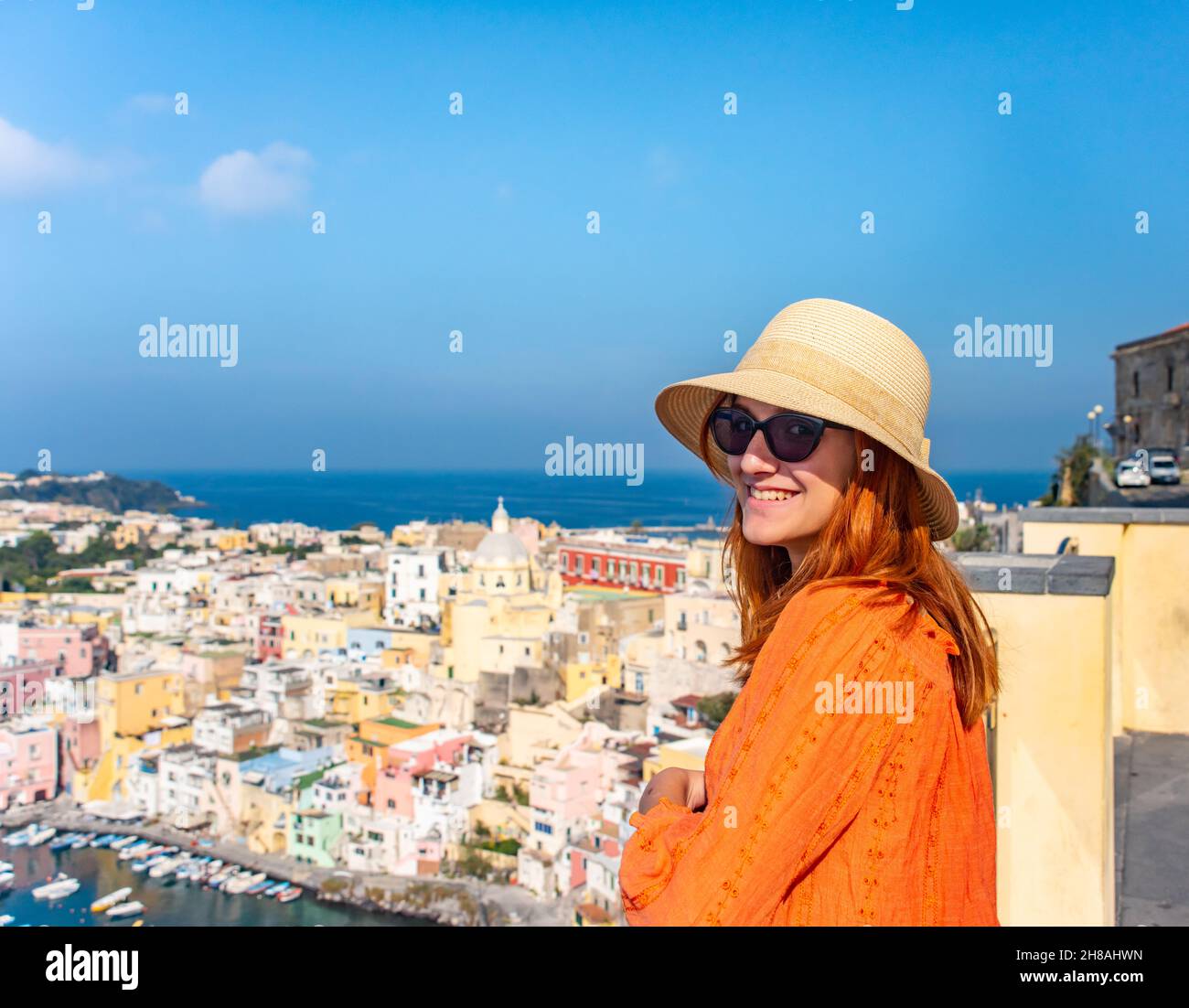 Beautiful young girl over panoramic view of Procida Island, Naples ...