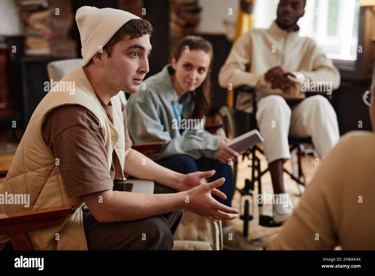 Guy talking to his teacher during a meeting in the classroom with other ...