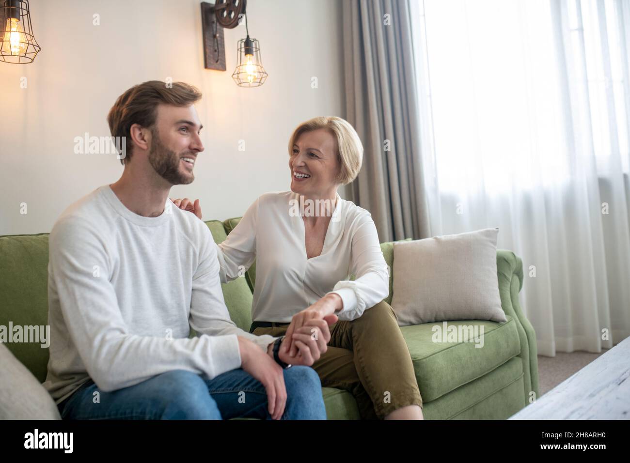 Son visiting his mom and both looking happy Stock Photo - Alamy