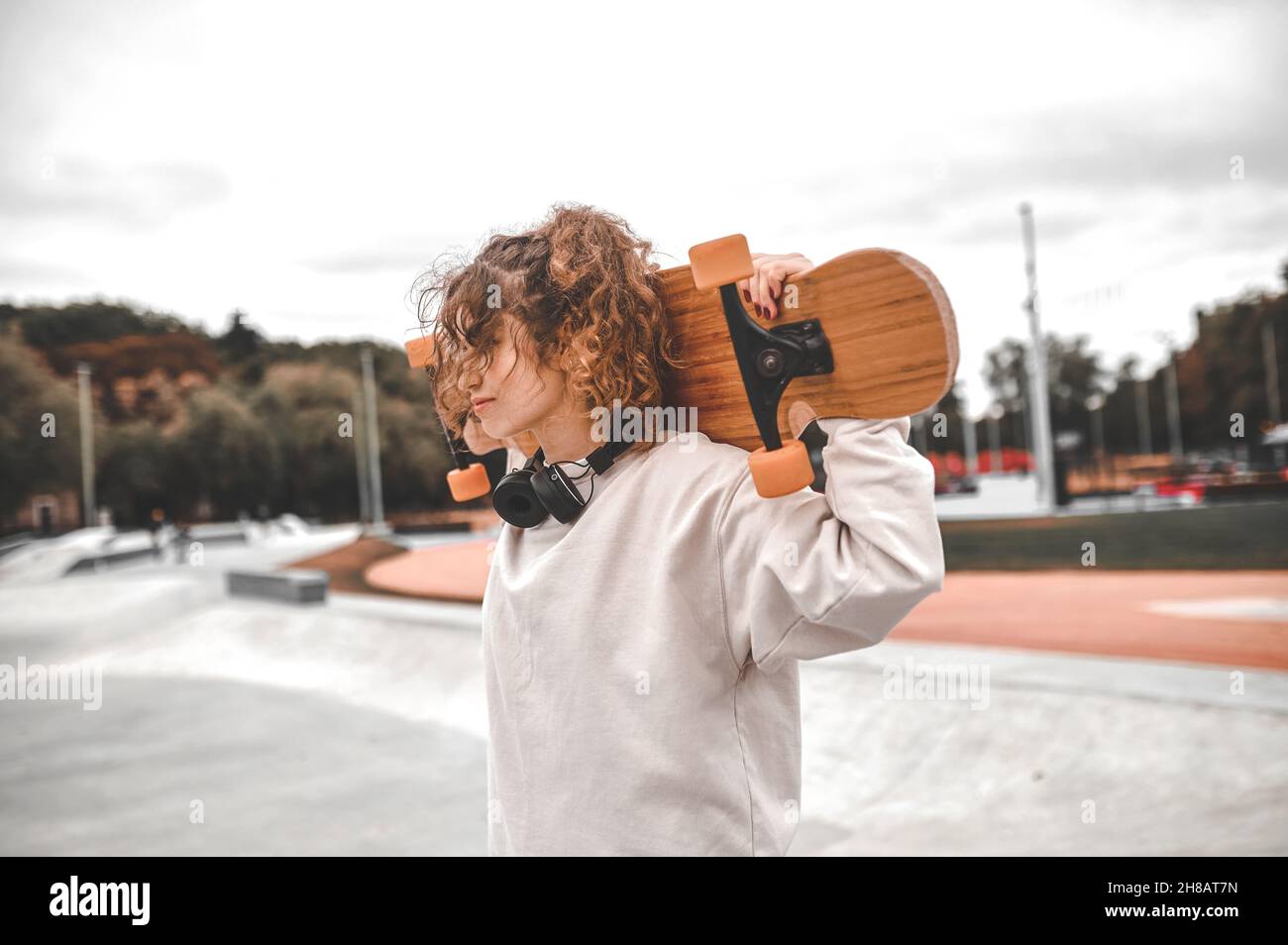 Profile of girl holding skeetboard on her shoulders Stock Photo - Alamy
