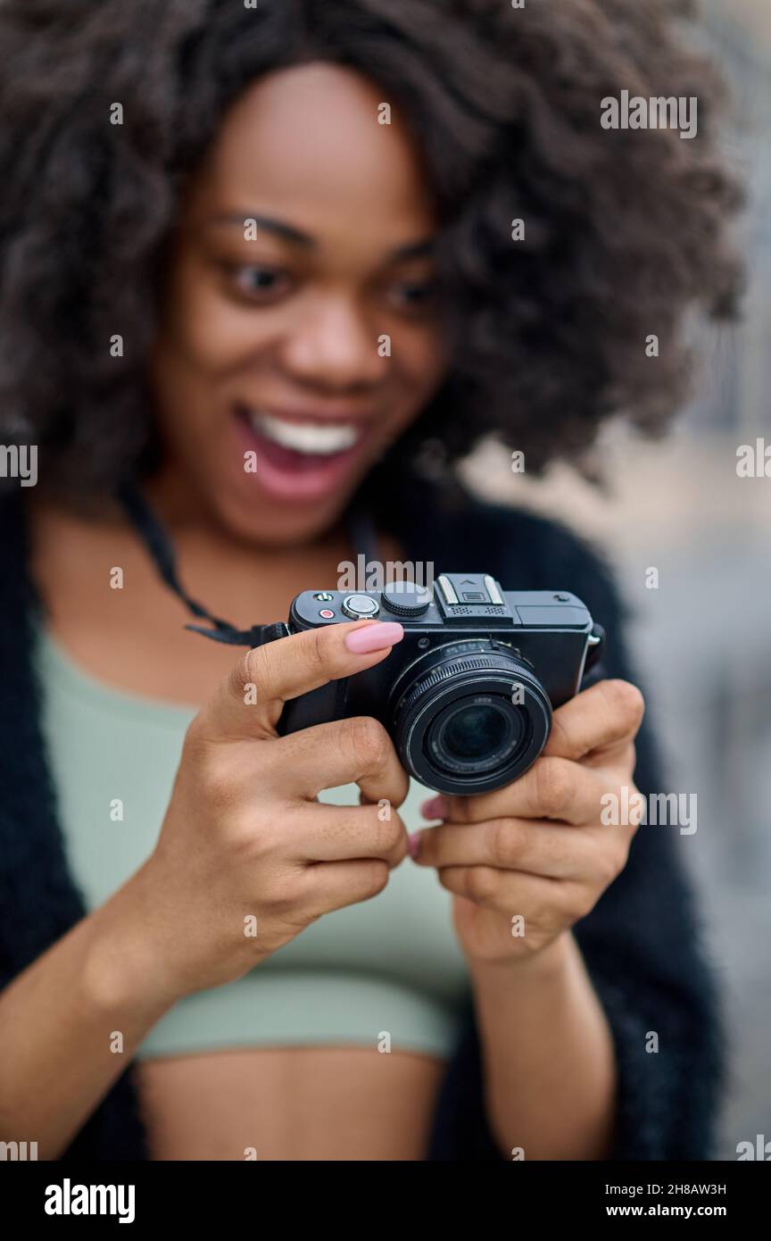 Pretty young female photographer checking photos Stock Photo - Alamy