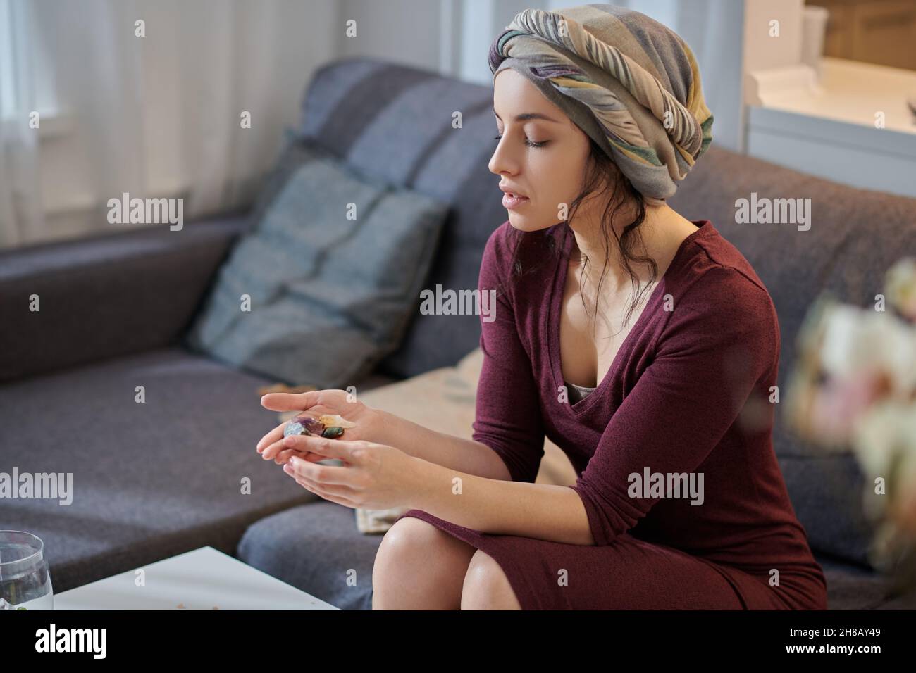 Focused woman scrutinizing healing gemstones in her hand Stock Photo ...