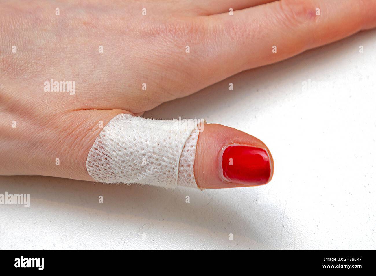 Plaster band on an injured female thumb finger Stock Photo - Alamy
