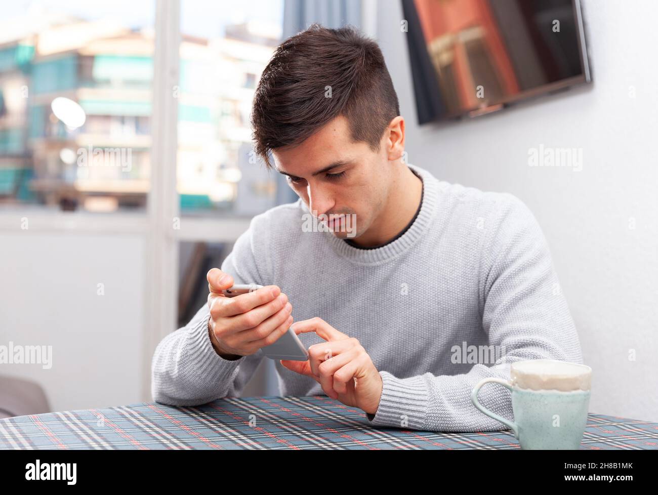 Young man is sad sitting with phone because she is alone Stock Photo ...