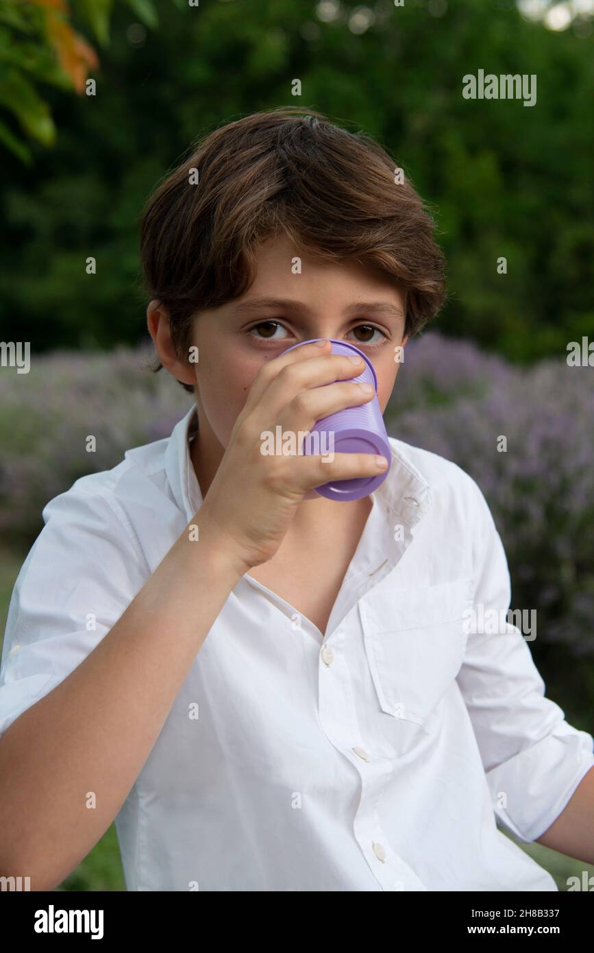 Portrait of boy drinking from cup in lavender field Stock Photo - Alamy
