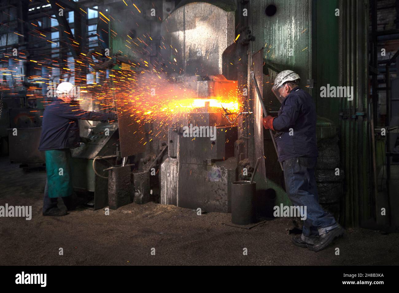 Sparks fly as counterblow hammer forms flight bar, the counterblow ...
