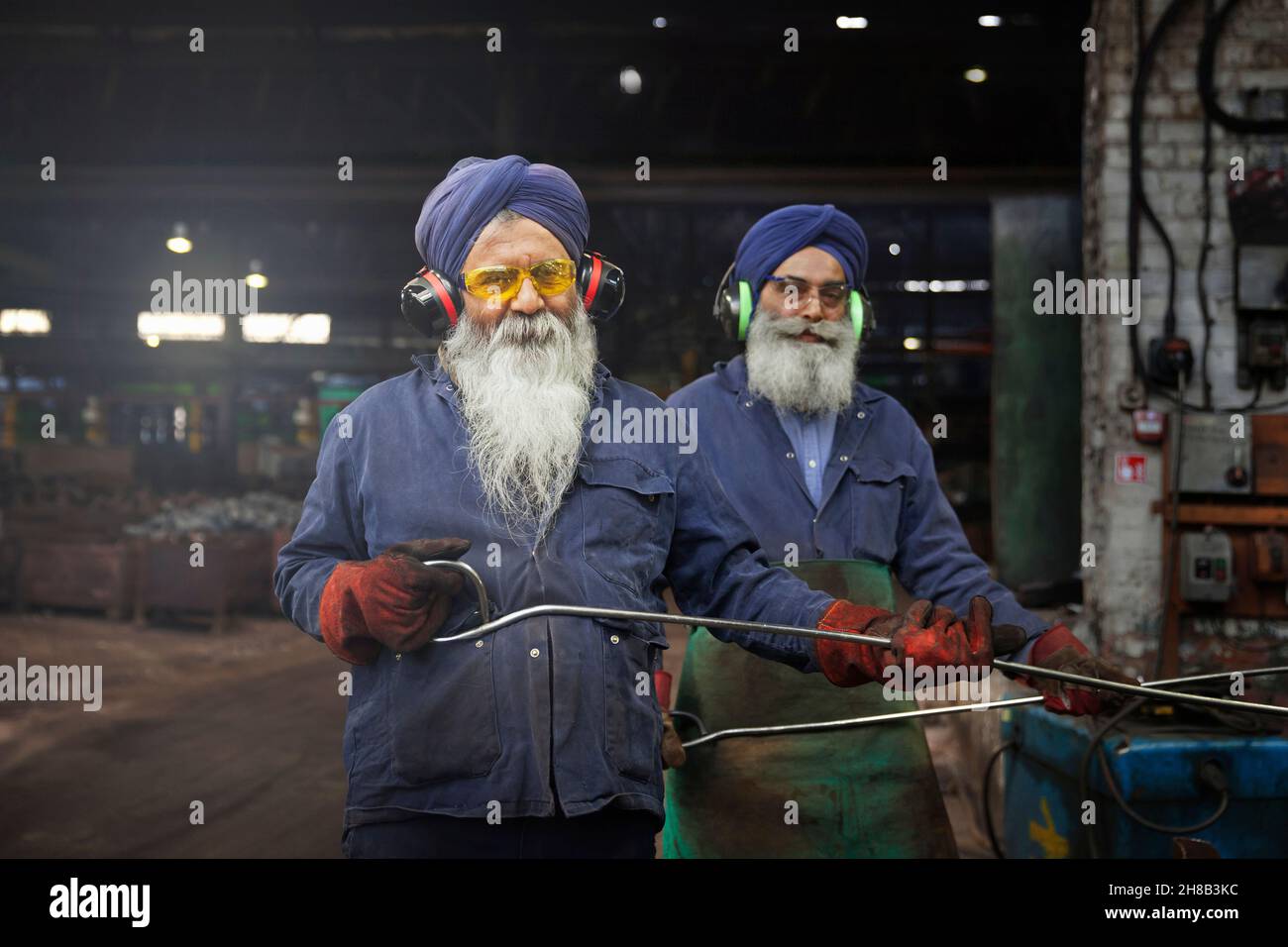 Forge workers pose whilst unloading forged components Stock Photo - Alamy