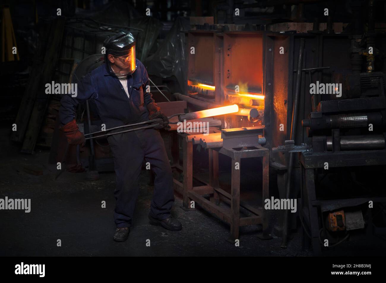 Forge worker pre heating steel billet for forging in upsetter Stock ...
