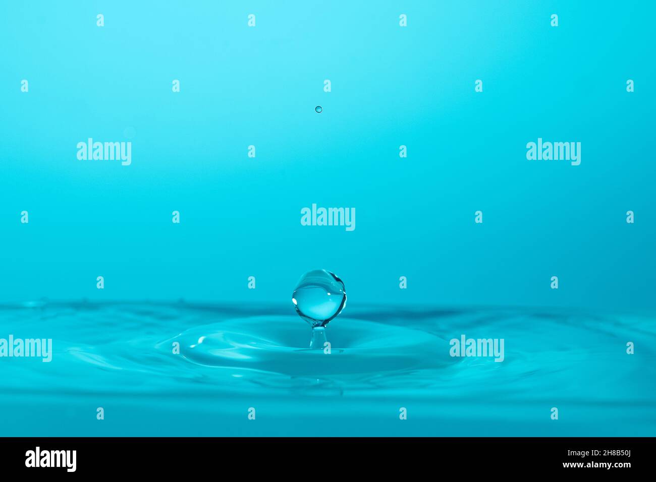 Water drop falling down. Abstract blue background Stock Photo - Alamy