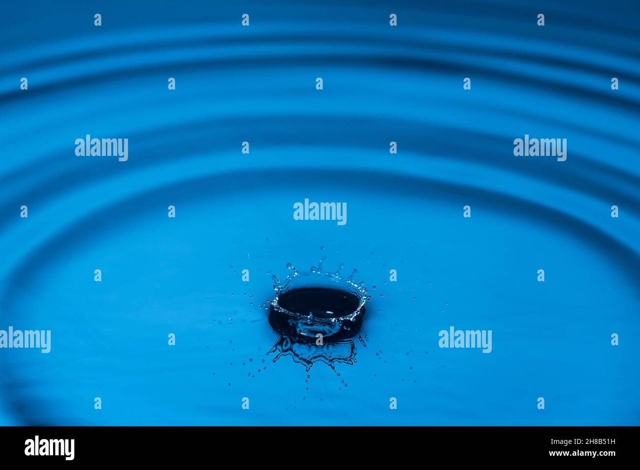 Water drop falling down. Abstract blue background Stock Photo - Alamy