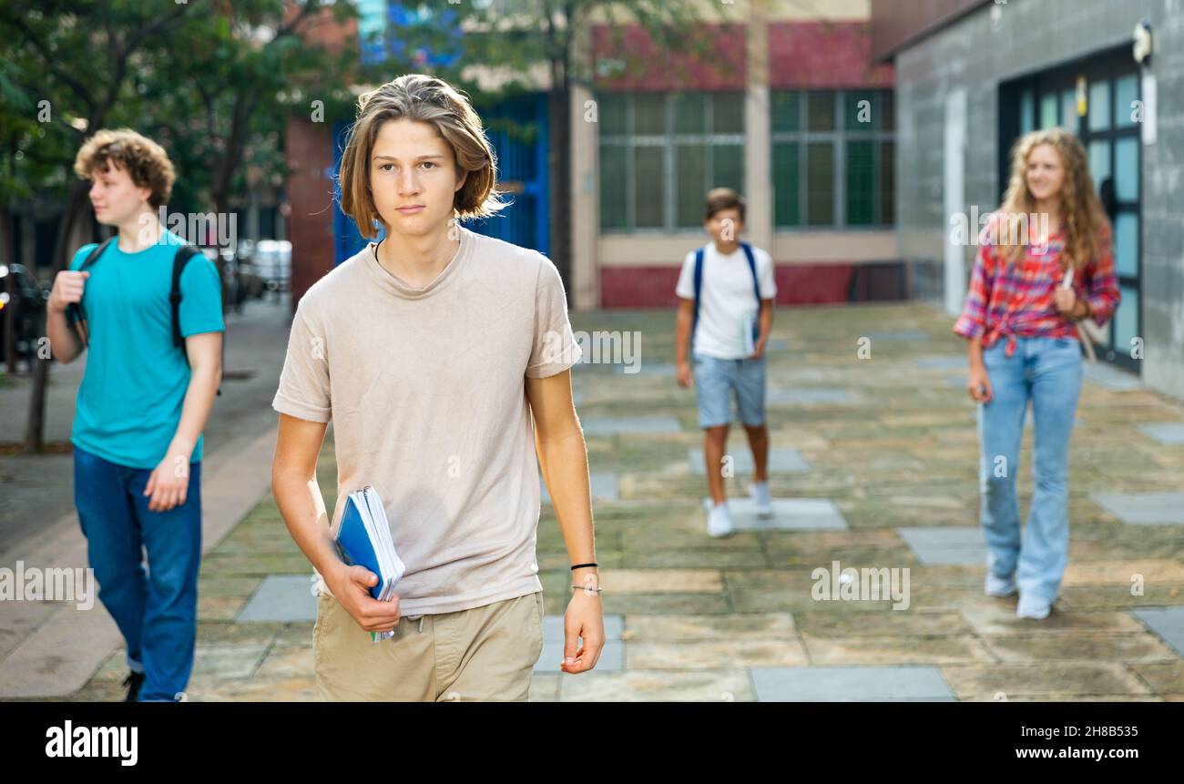 Teen boy walk along summer street after finishing college lessons Stock ...