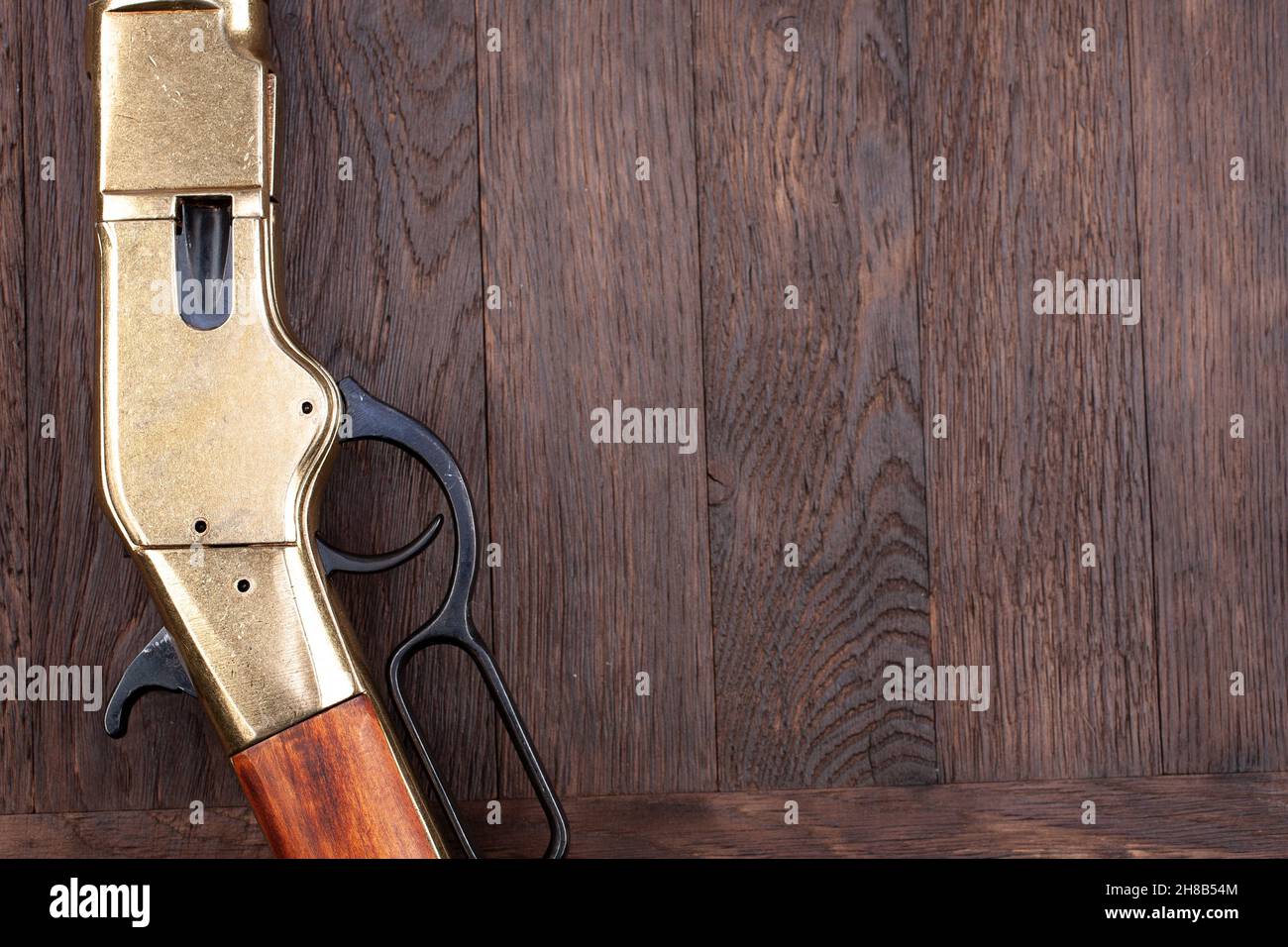 Old west gun - lever-action repeating rifle on wooden table Stock Photo ...