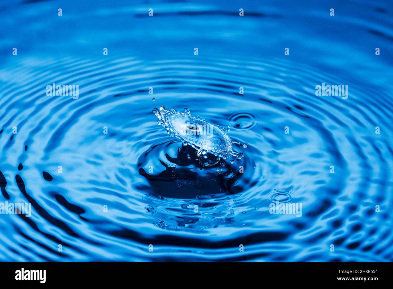Water drop falling down. Abstract blue background Stock Photo - Alamy