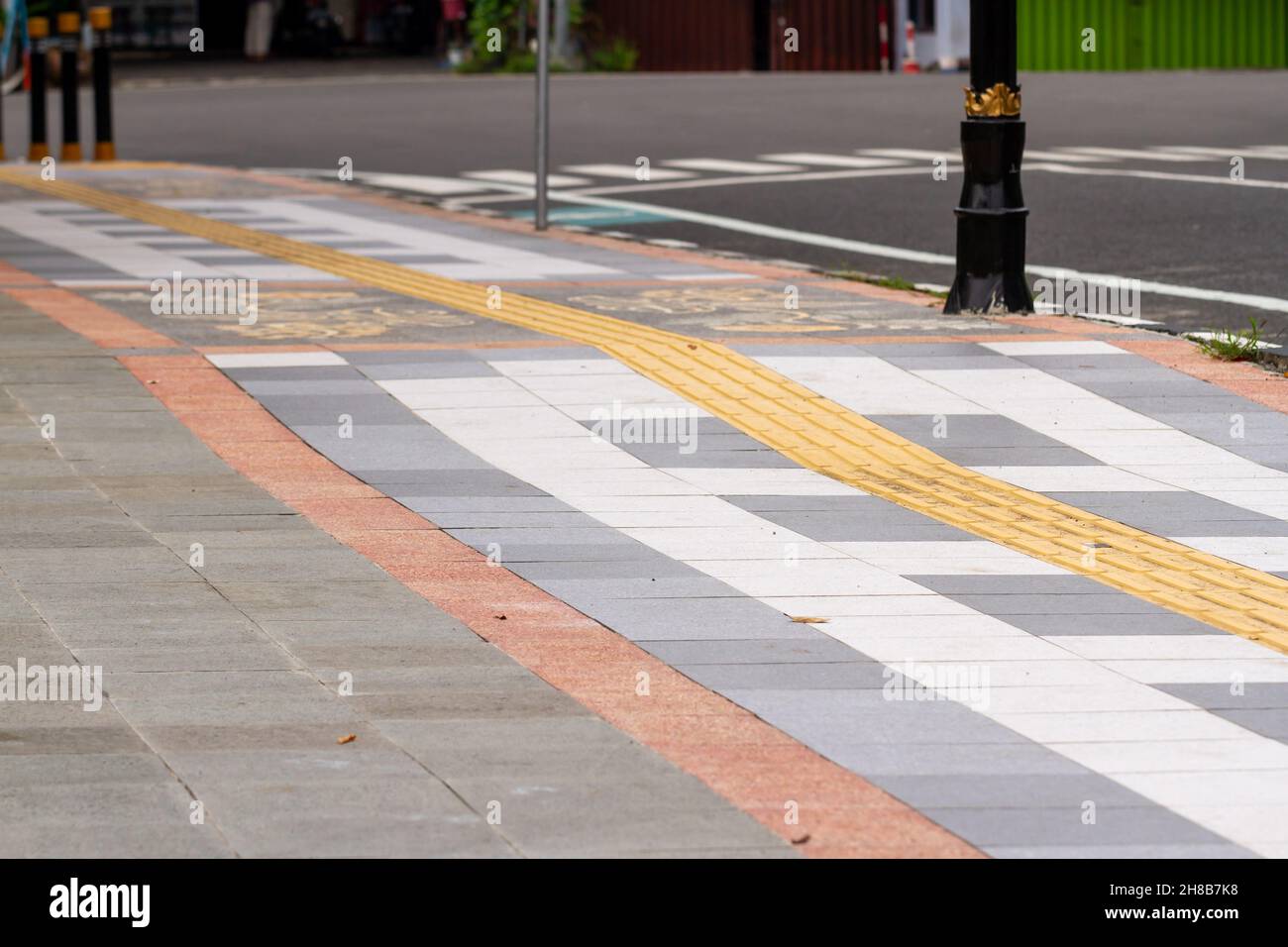 The sidewalk next to the highway is equipped with a path for people ...