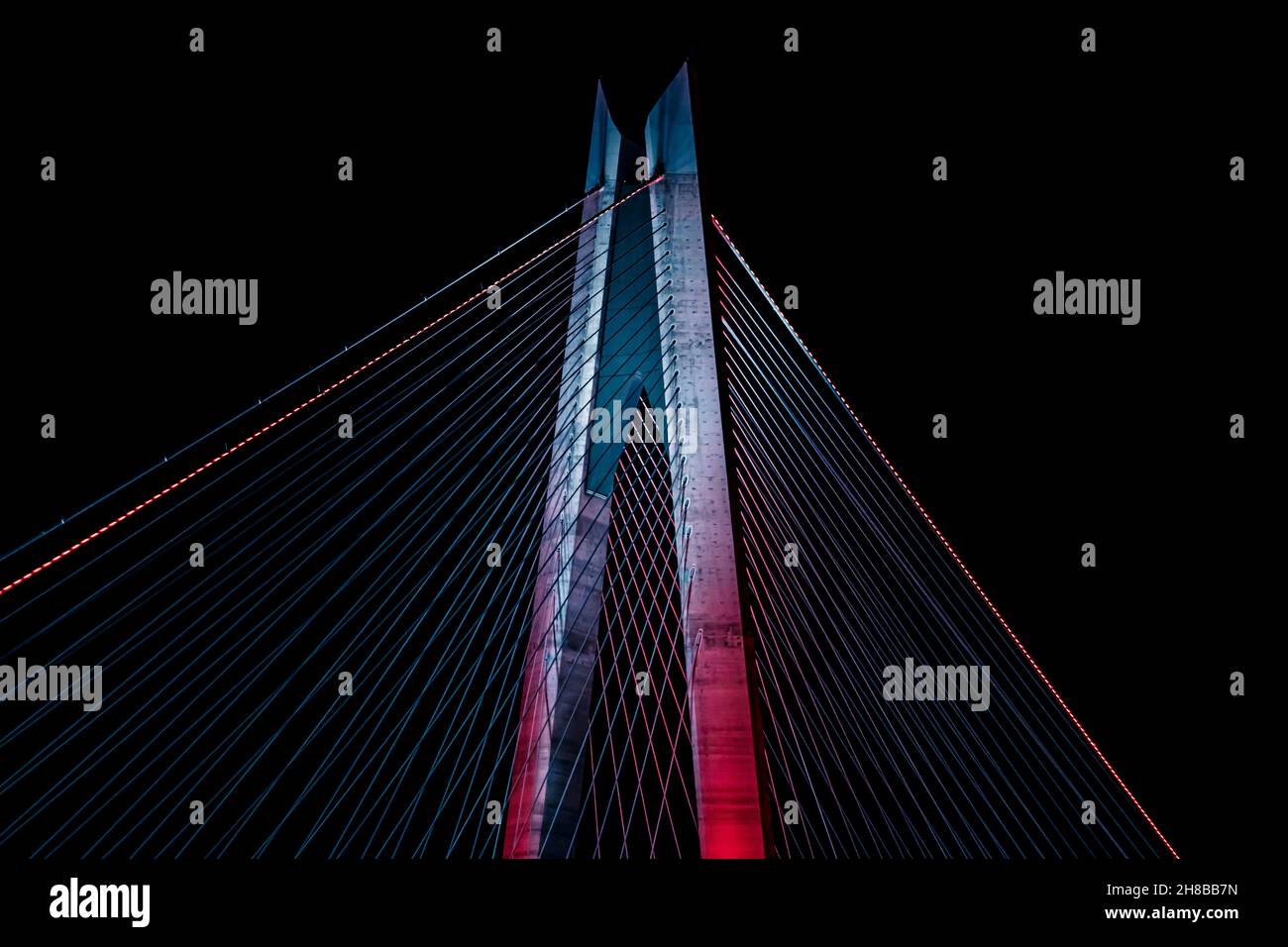 Colorful night view of hybrid cable-stayed, suspension bridge with neon ...