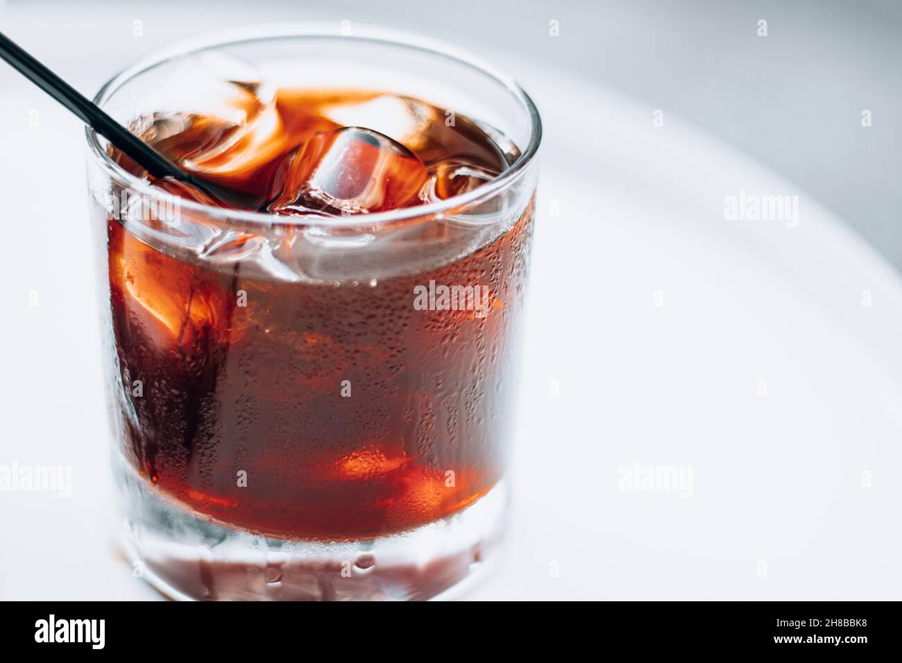Cold brew with full of ice and black straw on a white background ...