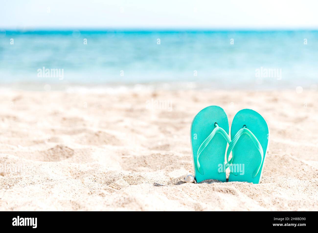 Flip flops stuck in the sand on a sandy beach by the sea or ocean Stock ...