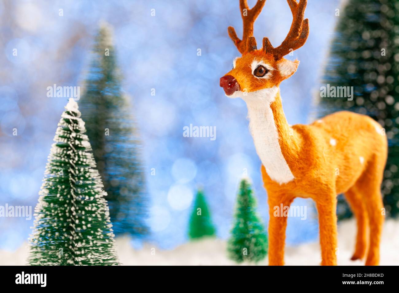 Christmas greeting card with toy reindeer, artificial pine trees Stock ...