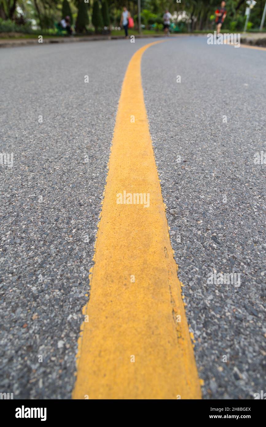 Close up of yellow line on the public park with people exercise and ...