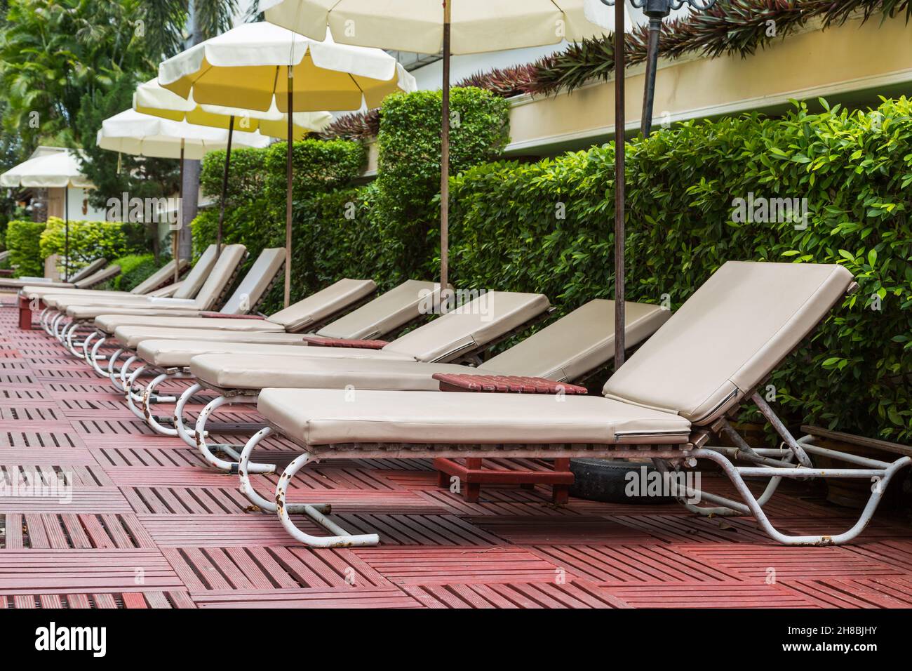 Pool chair side of swimming pool background Stock Photo - Alamy