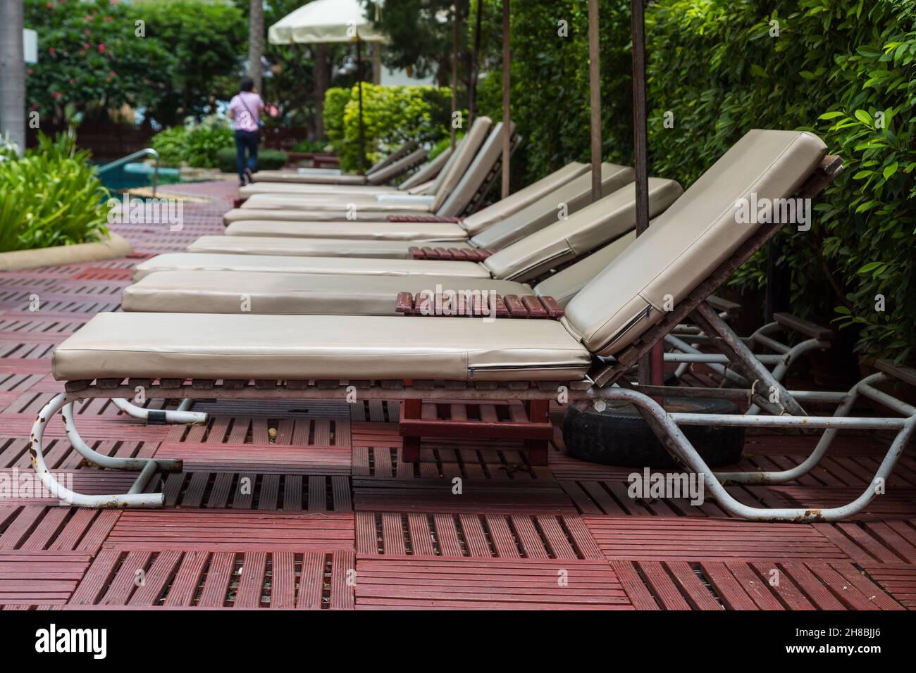 Pool chair side of swimming pool background Stock Photo - Alamy