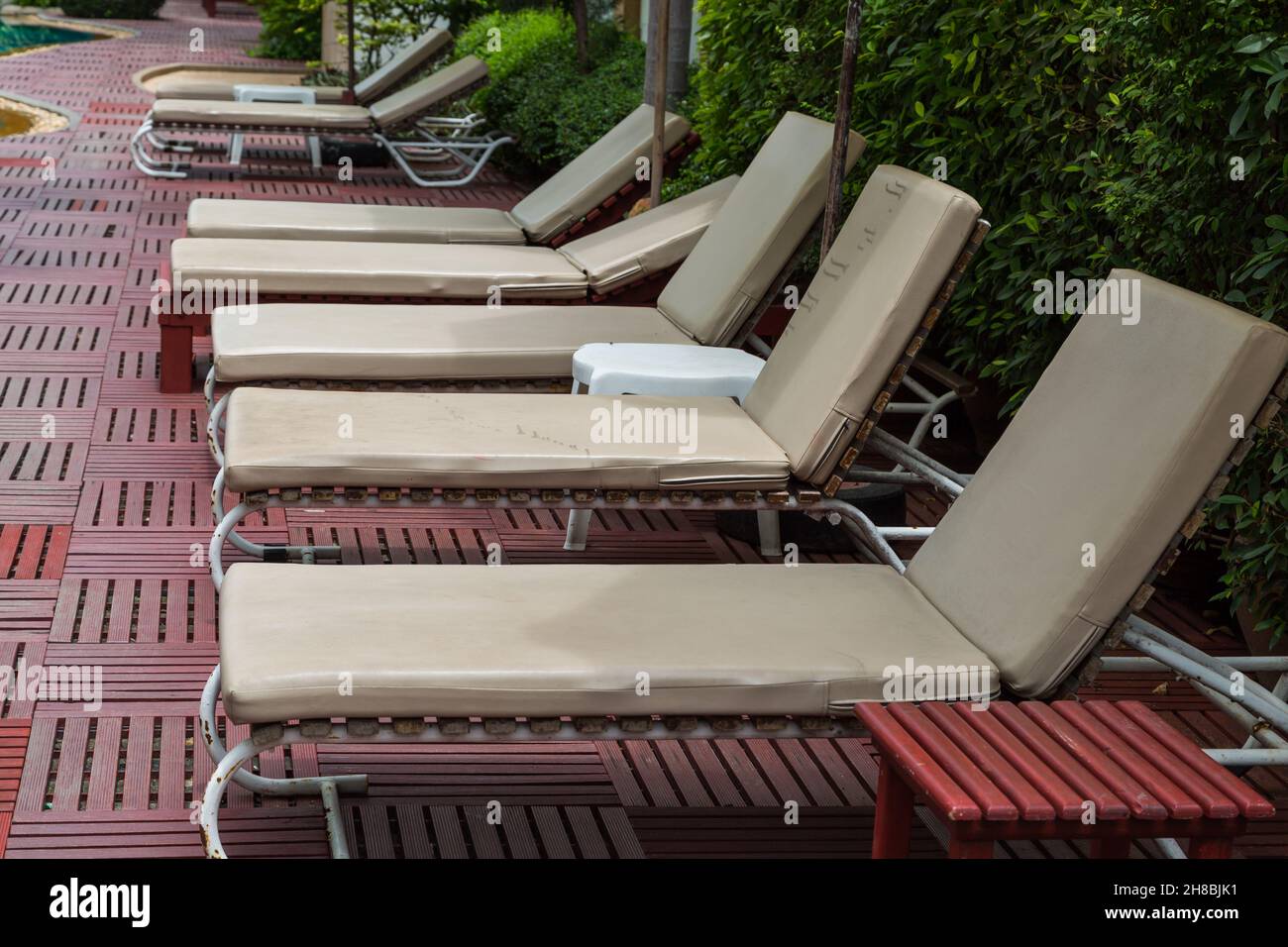 Pool chair side of swimming pool background Stock Photo - Alamy