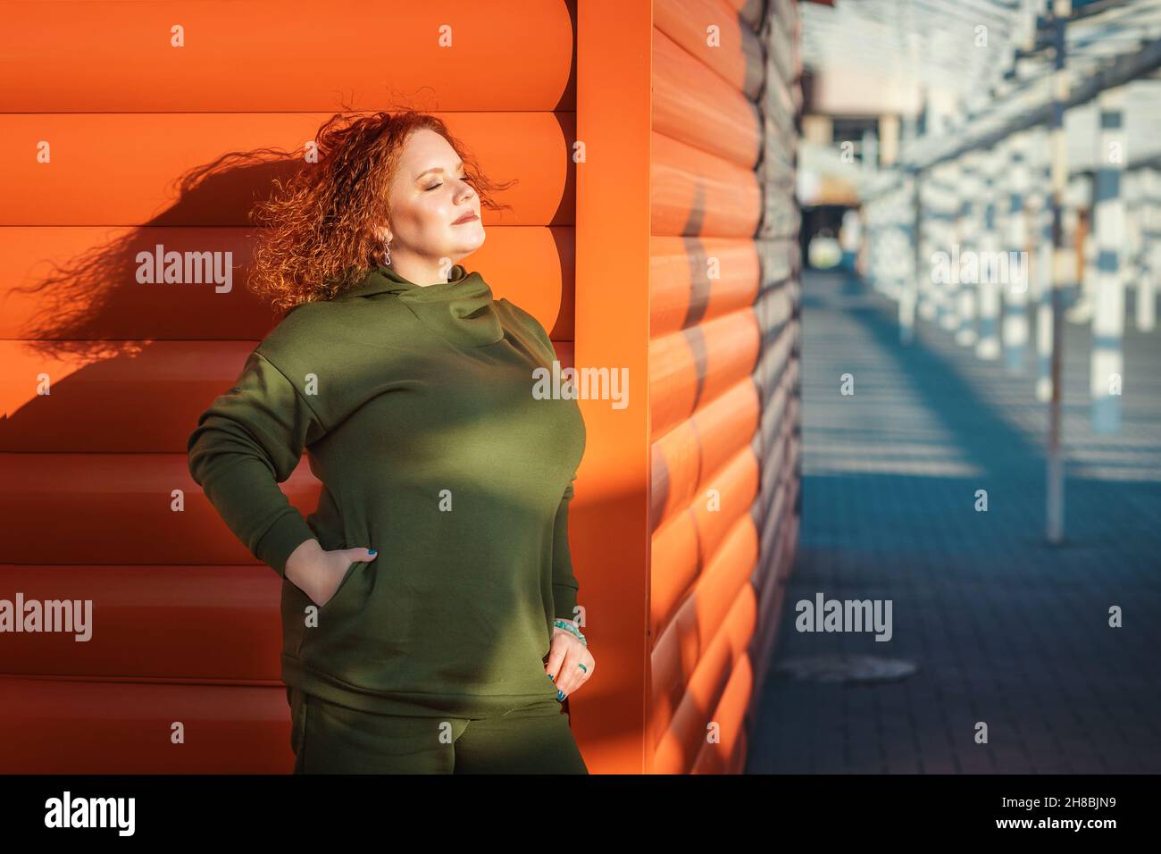 A beautiful young overweight woman confidently poses on the street. The ...